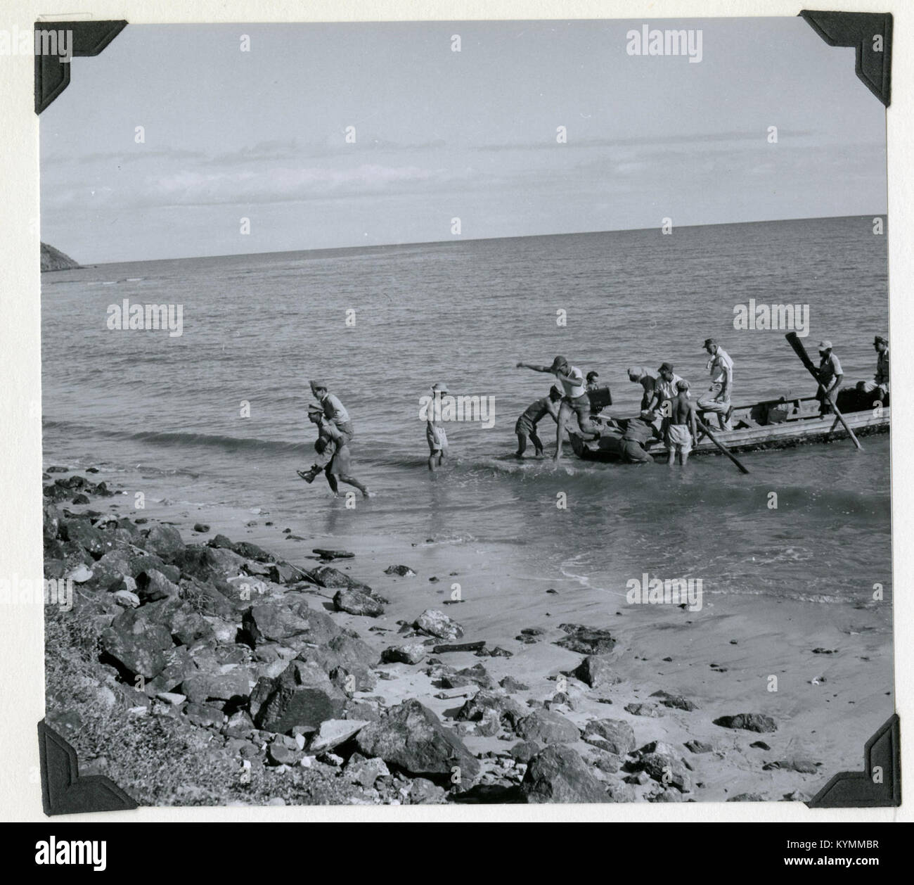 This photograph from 1956 shows a police officer going ashore pickaback ...