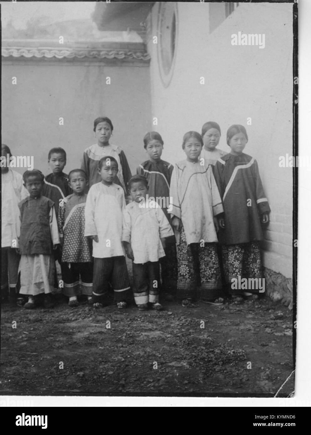 A historical photograph depicting a Chinese teacher with students in a ...