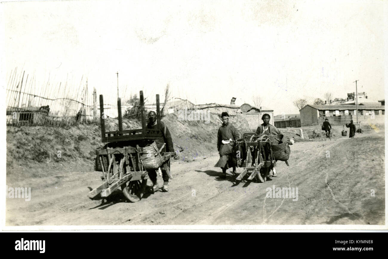 A photograph from China, showing people pushing carts in a rural or ...