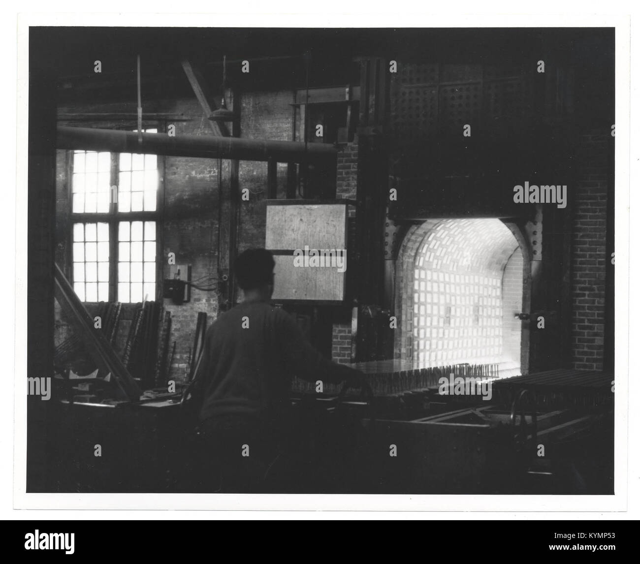 A historical image of an unidentified man working at a kiln, showcasing ...
