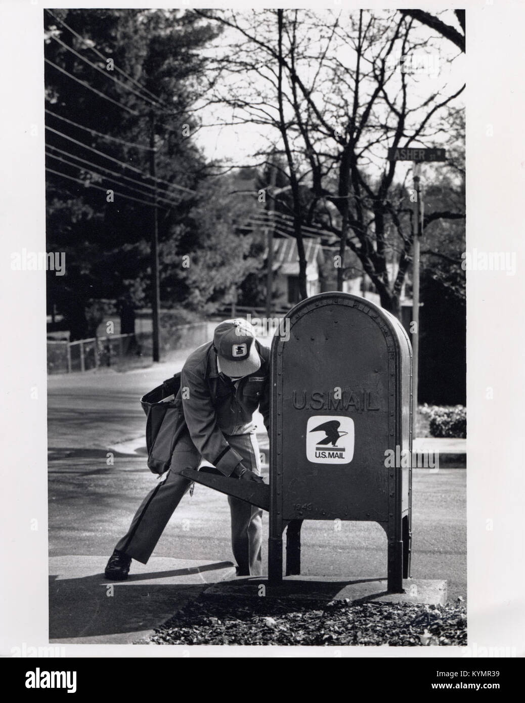 This image captures a letter carrier retrieving mail from a mailbox in ...
