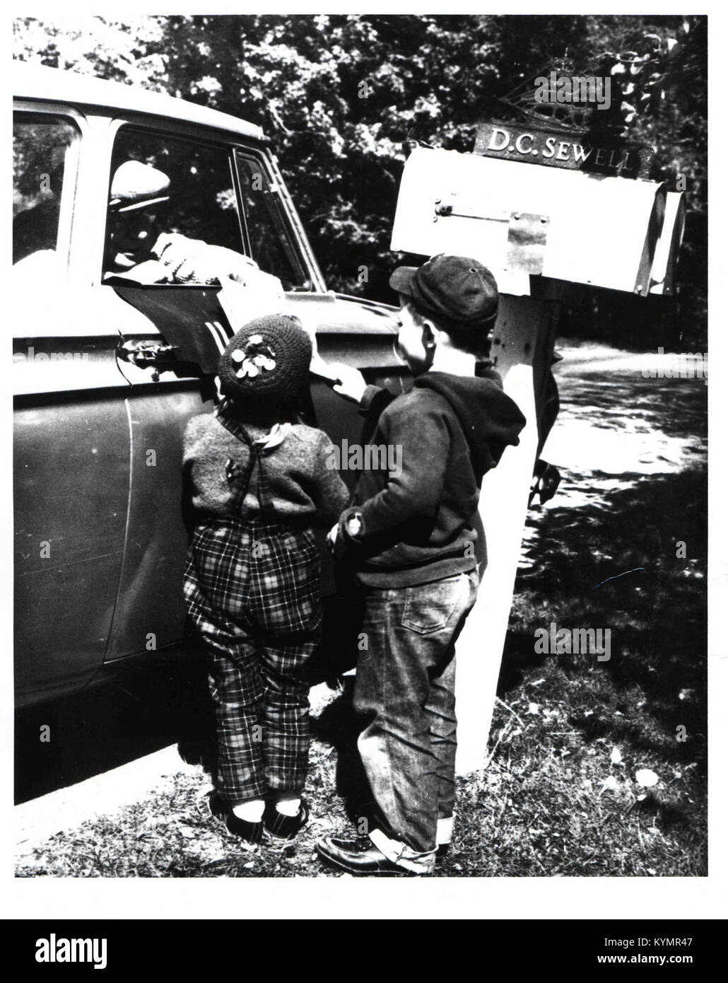 A historical image depicting a rural mail carrier being greeted by ...