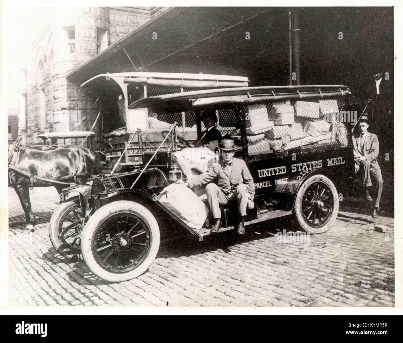 A photograph depicting early parcel post vehicles and postal employees ...