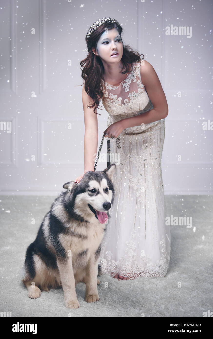 Pretty ice queen with dog among snow falling Stock Photo - Alamy
