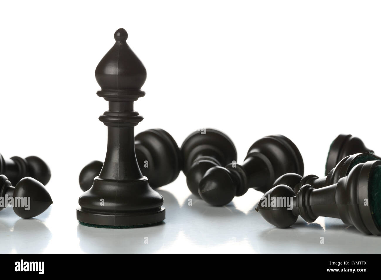 Runner chess figure standing in between fallen over pawn chess figures ...