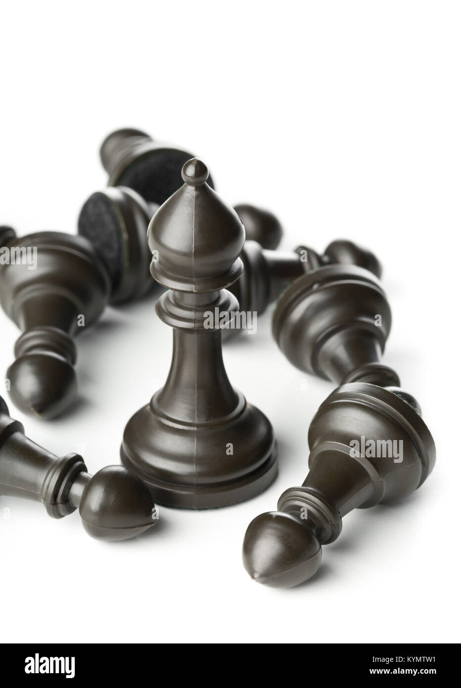 Runner chess figure standing in between fallen over pawn chess figures ...