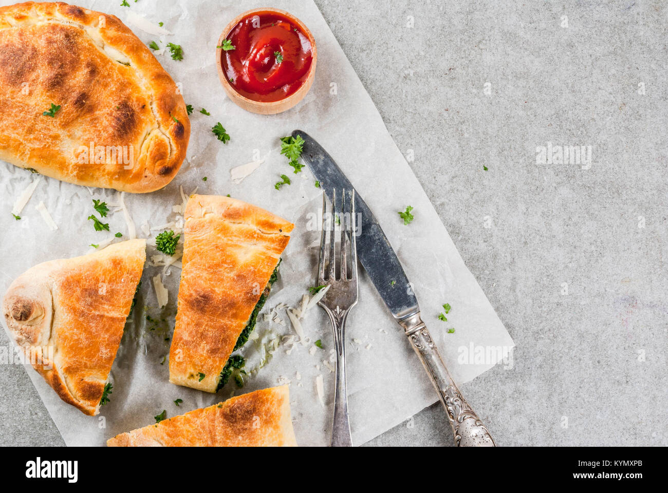 Italian food, closed pizza calzone with Spinach and Cheese, gray stone ...