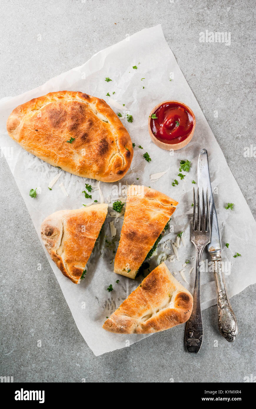 Italian food, closed pizza calzone with Spinach and Cheese, gray stone ...