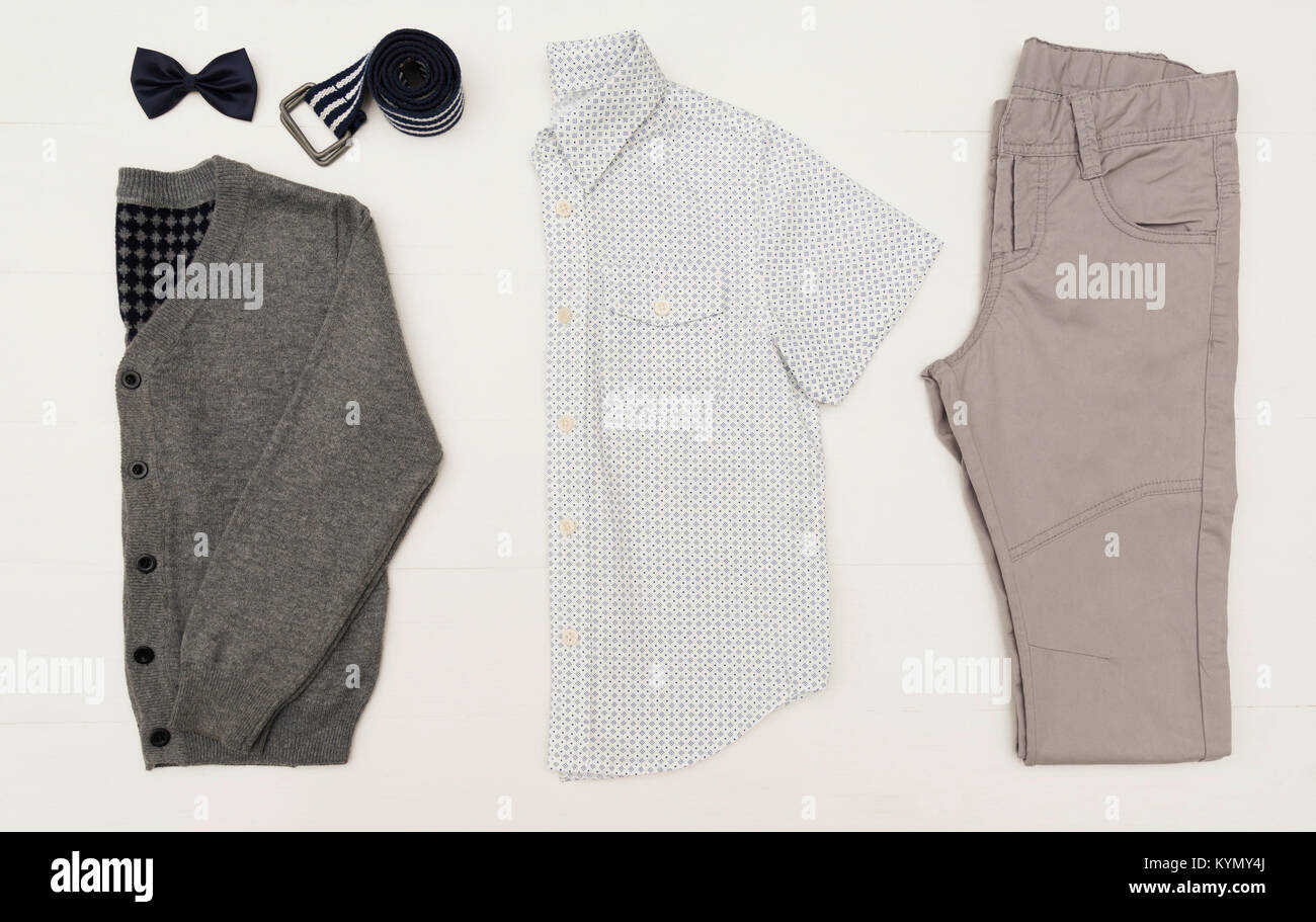 Top view fashion trendy look of kids clothes on white wooden background ...