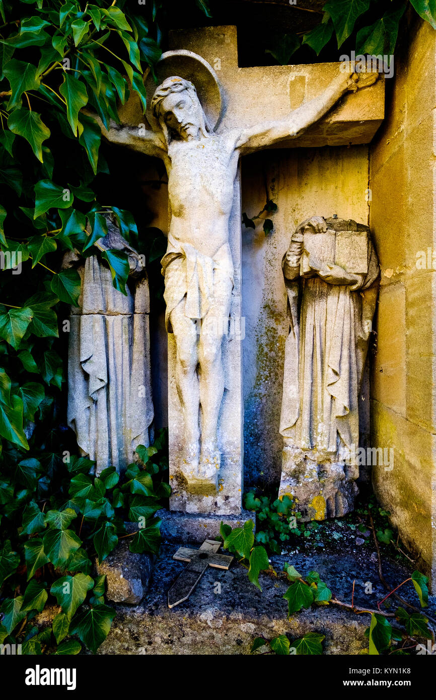 Ivy-covered graveyard monument of Jesus on the cross Stock Photo - Alamy