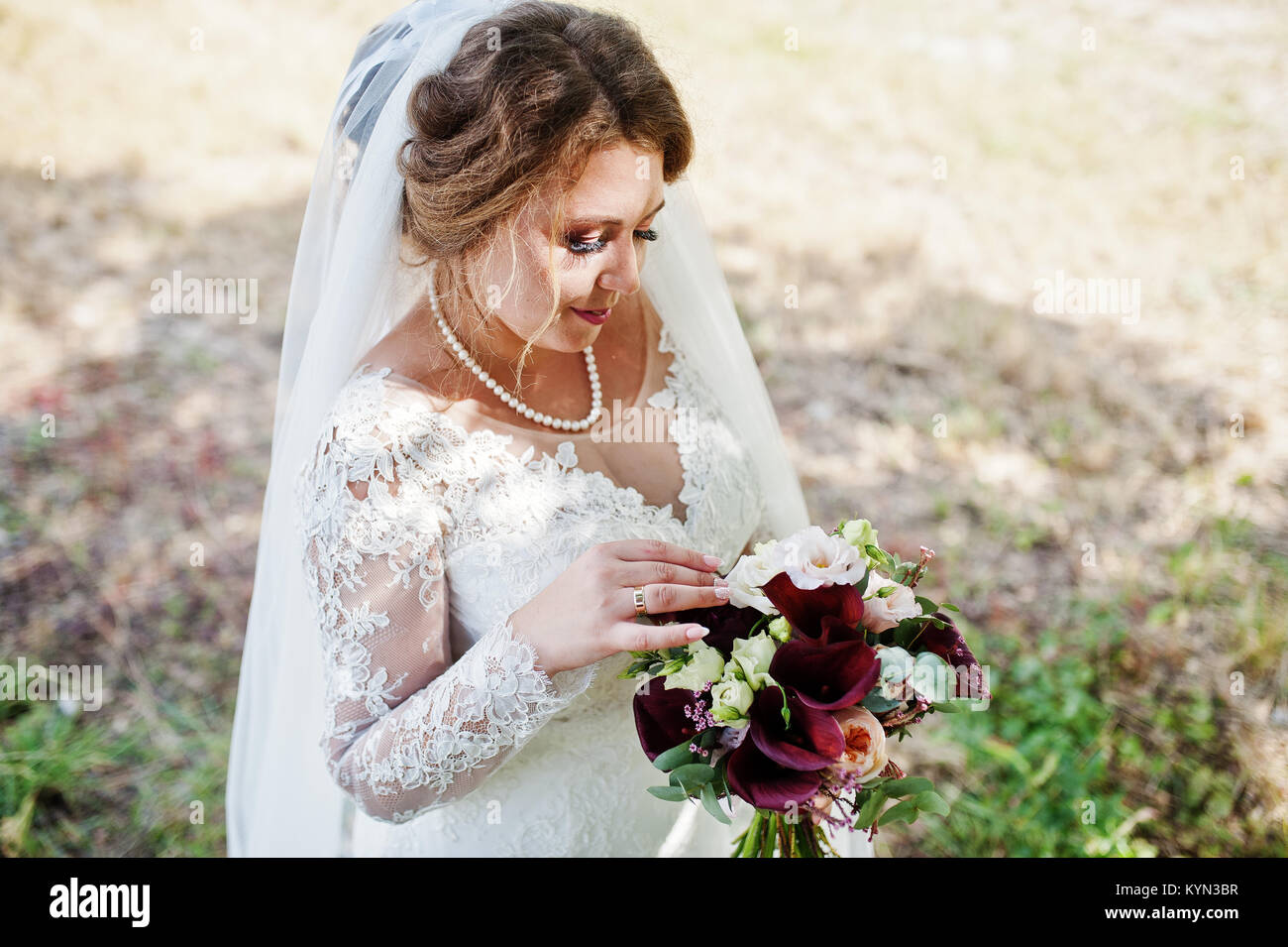 Lonely bride posing in her white dress on her own in the park Stock ...