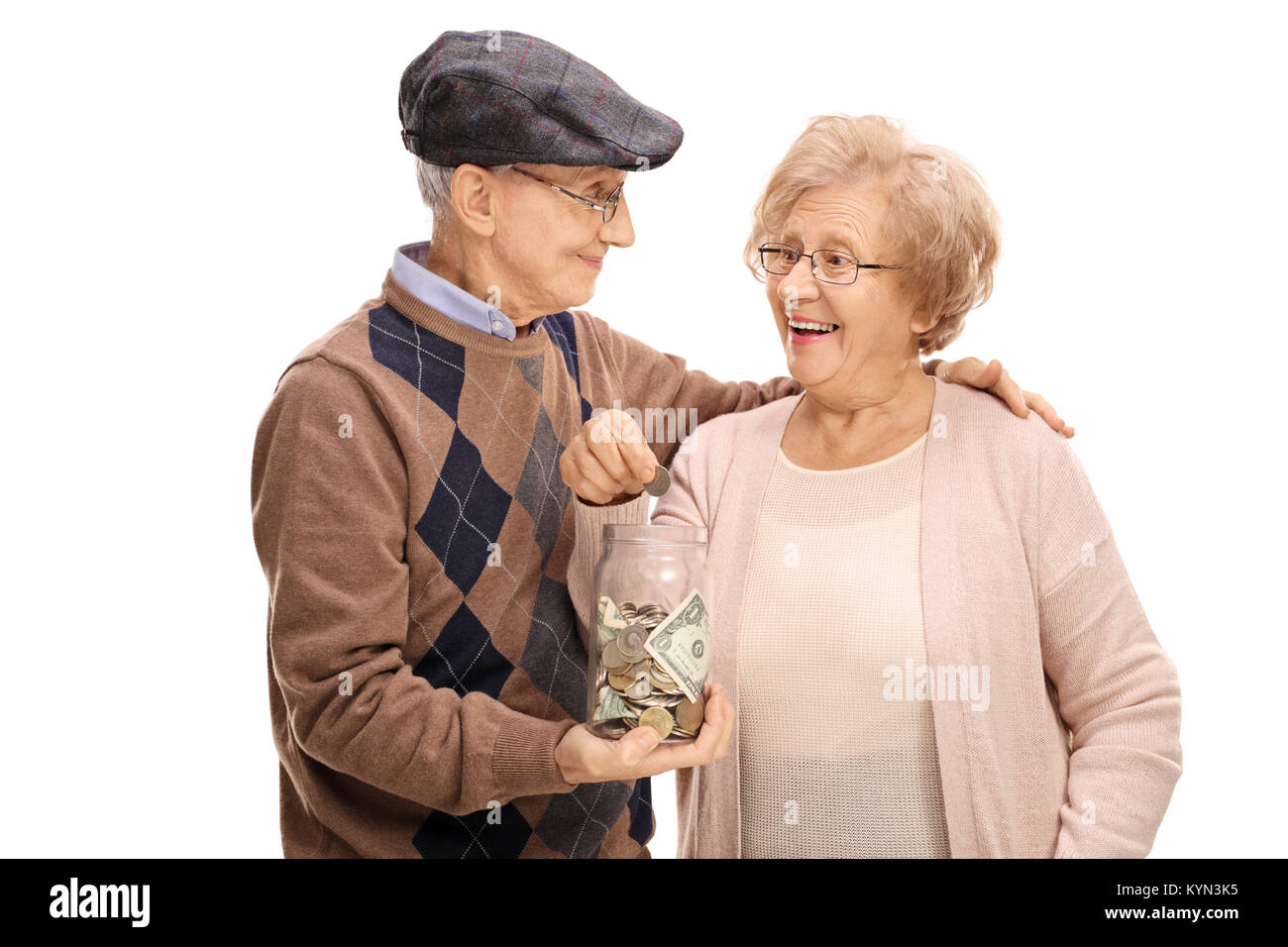 Elderly couple putting a coin into a money jar isolated on white ...