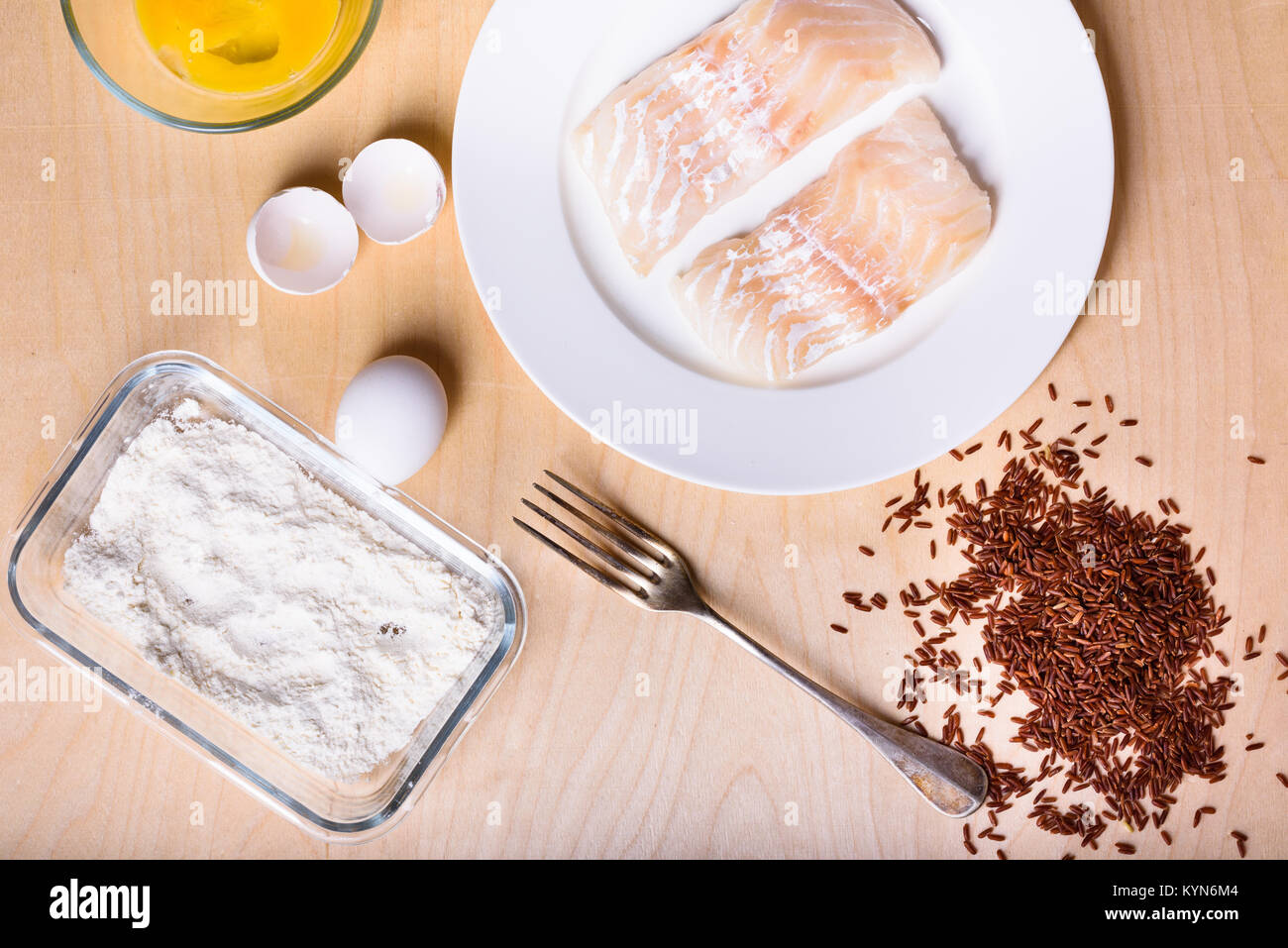 Raw fish cooking and ingredients. Cod fillet, egg and rice. Top view ...