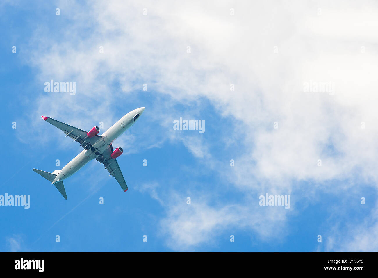 Unidentifiable Airplane flying over head with bright blue sky heading ...