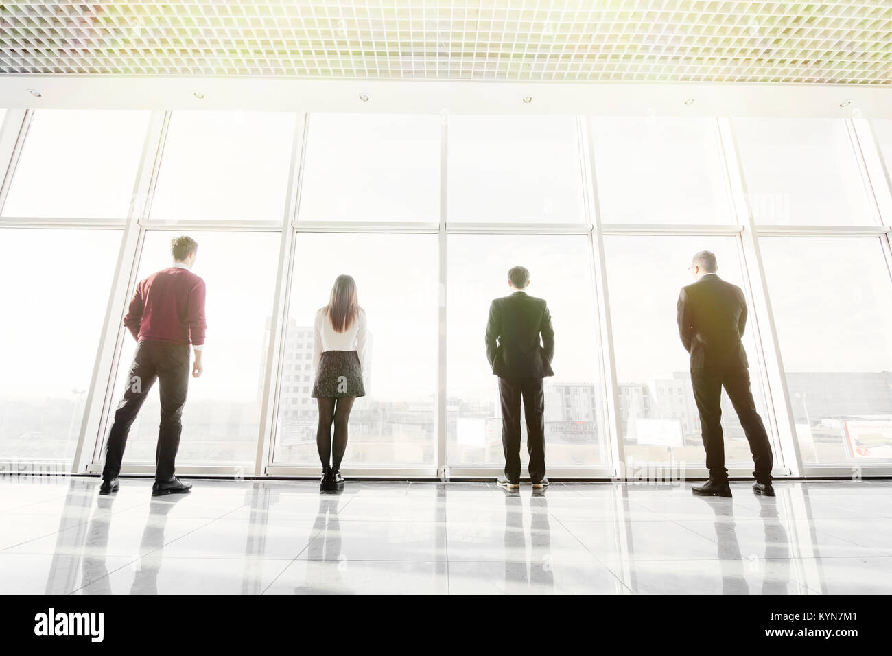 Back view silhouettes of fouw business partners looking thoughtfully ...
