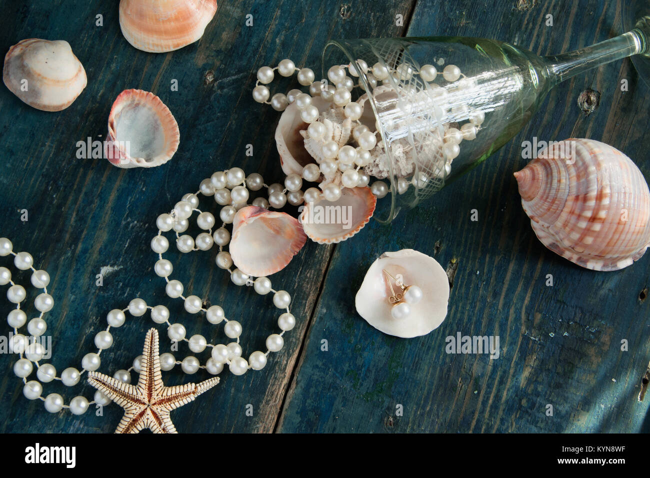 The pirate's treasure - white pearls and shells on blue wooden ...
