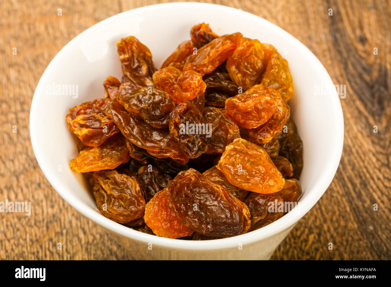 Dry Raisin in the bowl over the wooden background Stock Photo - Alamy