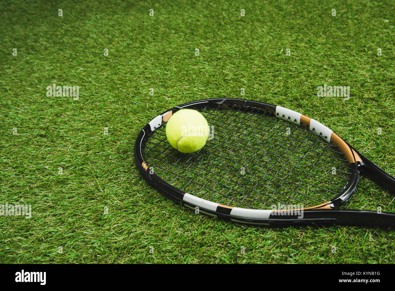 close up view of tennis racket and ball on green lawn Stock Photo - Alamy