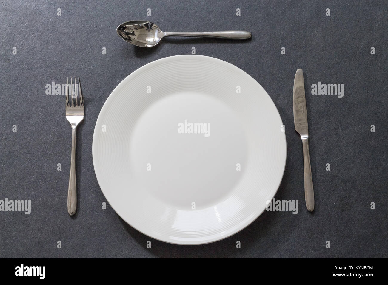 Table setting with dinner plate empty round white plate on dark ...