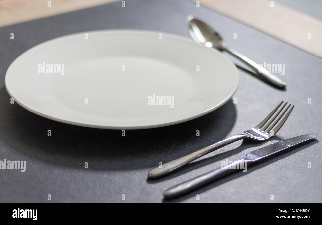 Table setting with dinner plate empty round white plate on dark ...