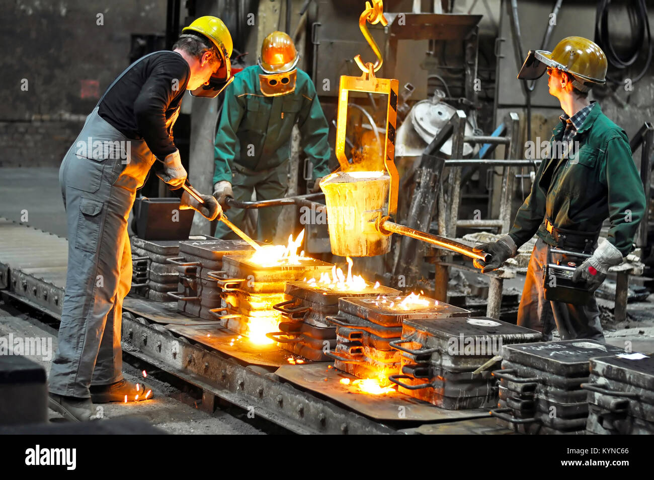 Group of workers in a foundry at the melting furnace - production of ...