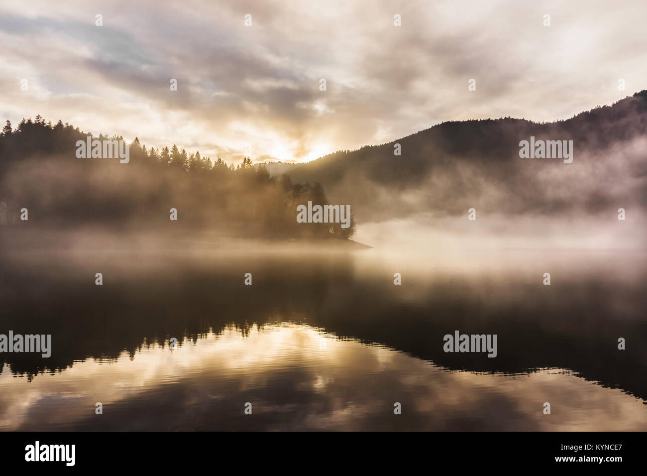 Sunset on the Kruth-Wildenstein Lake during a misty day of winter ...