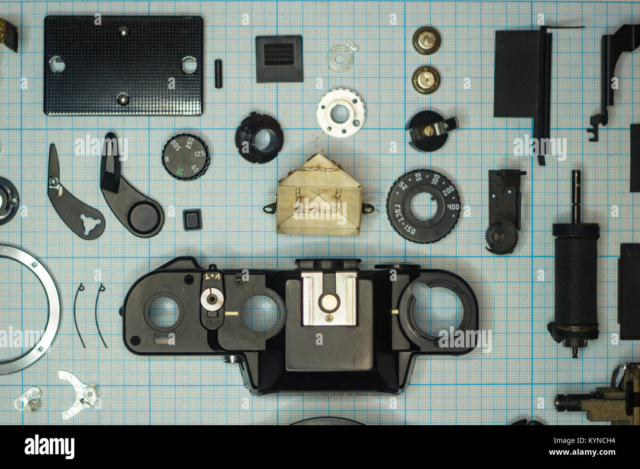 parts are completely disassembled old retro film SLR camera on graph ...