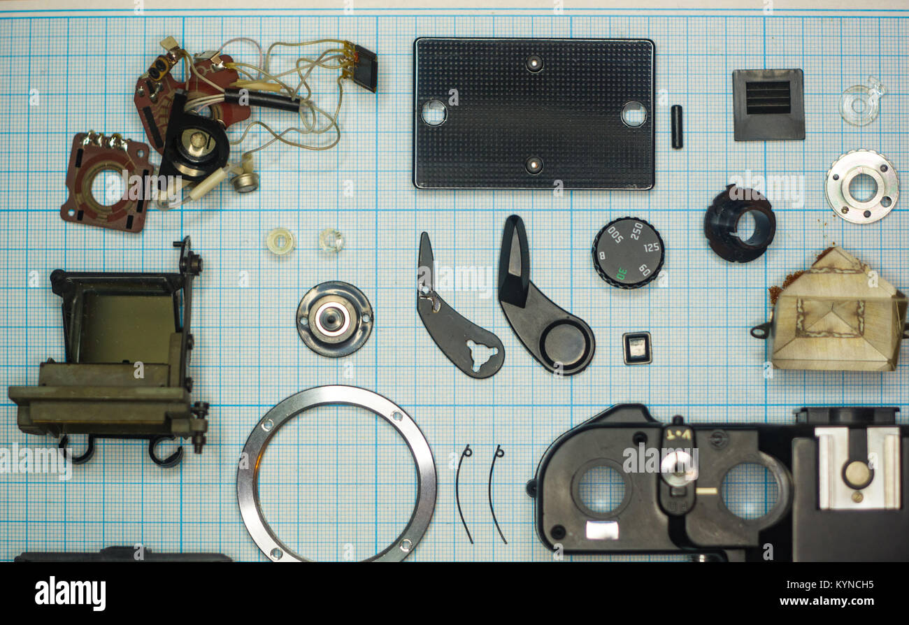 parts are completely disassembled old retro film SLR camera on graph ...