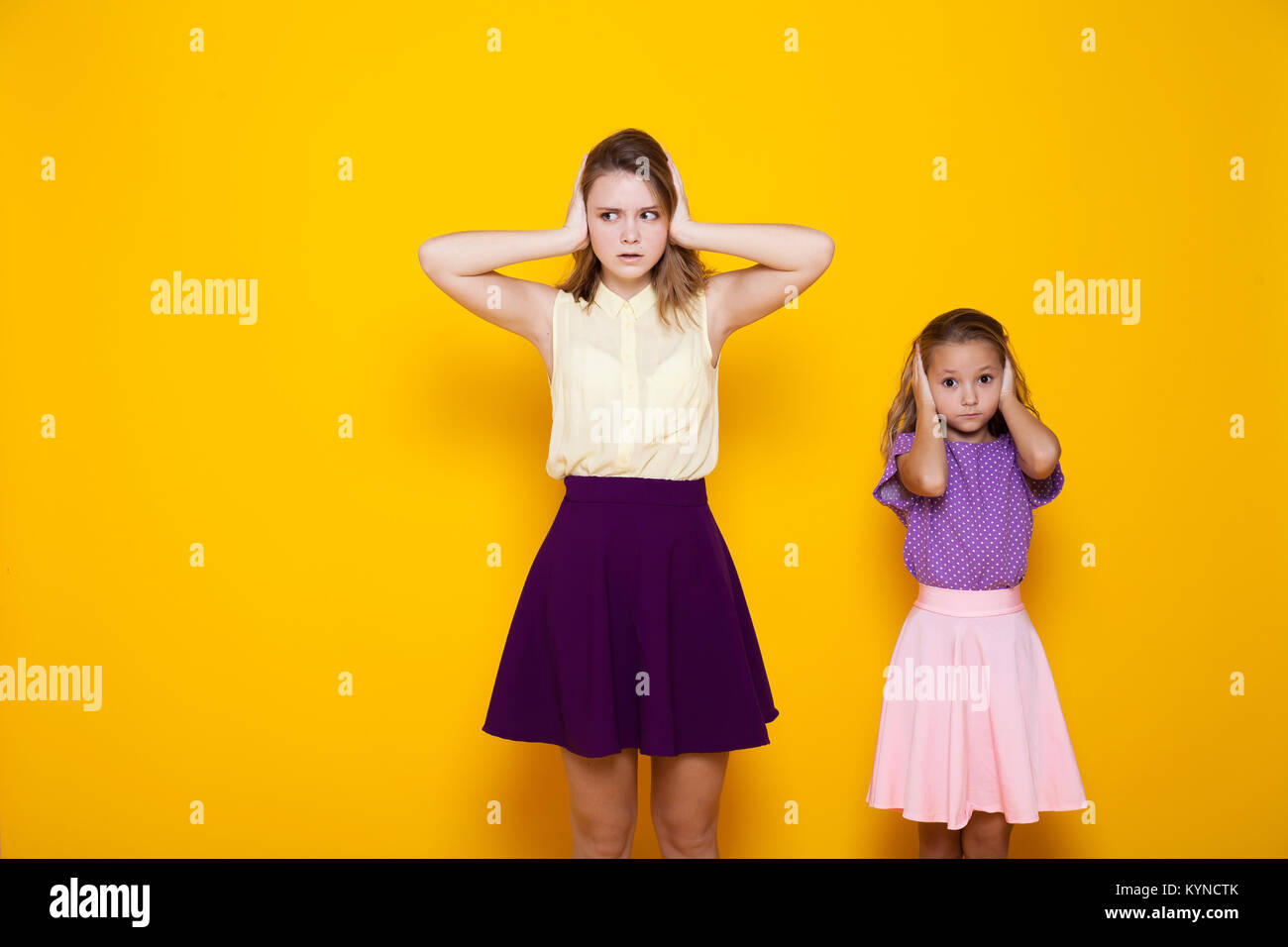 two girls close their ears Stock Photo - Alamy
