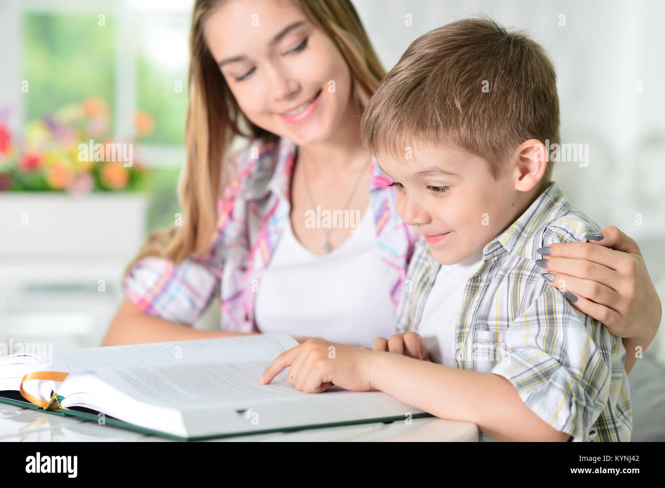 Bother and sister reading book Stock Photo - Alamy