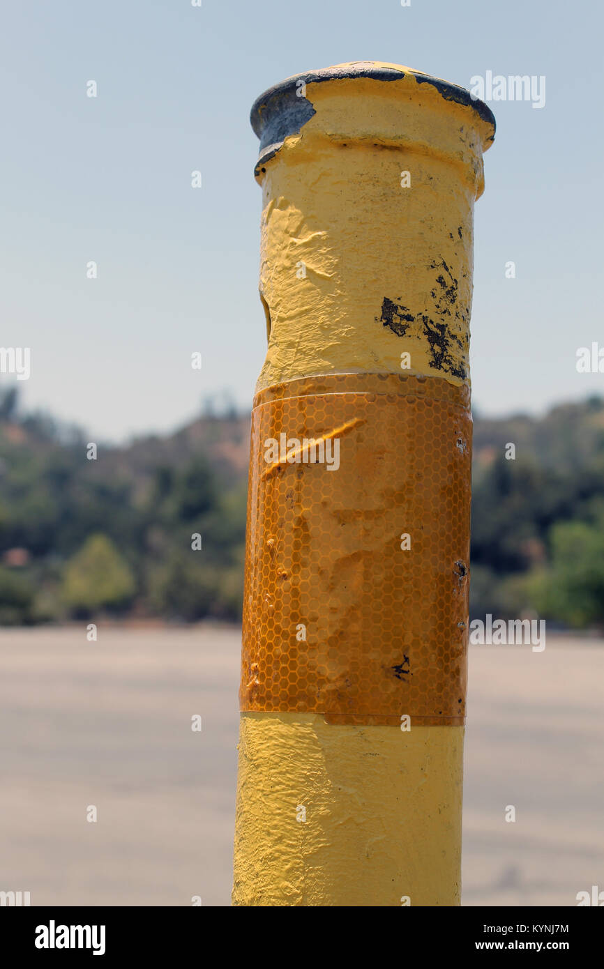 Yellow post with parking lot in background Stock Photo - Alamy