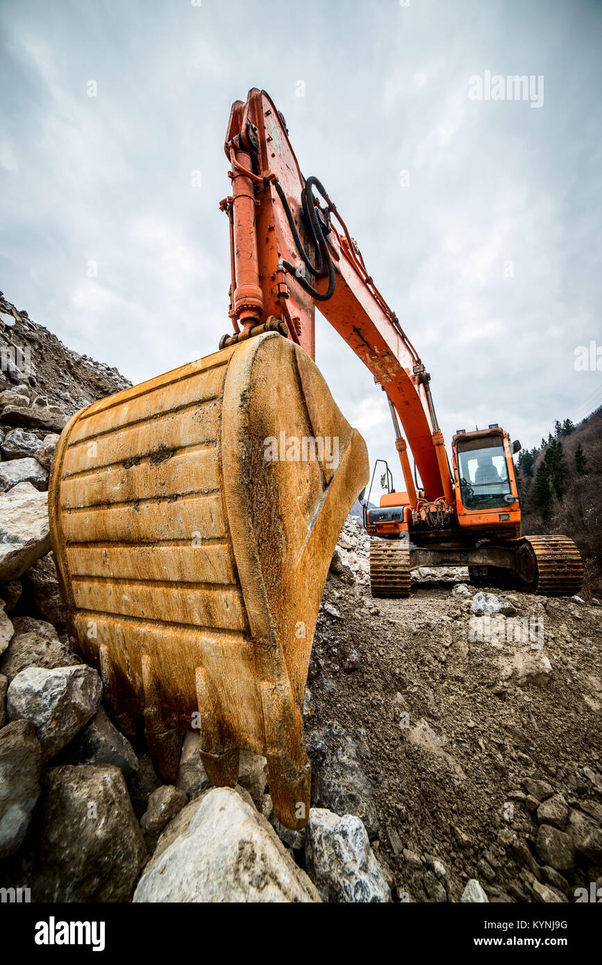 excavator is making pile of soil by pulling ground up on heap at ...