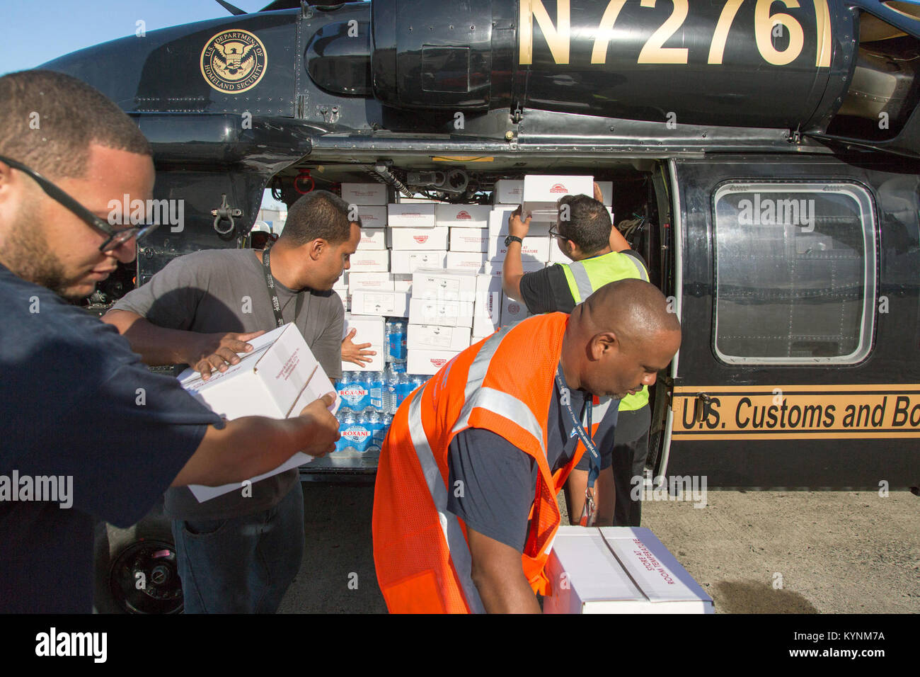 CBP personnel load bottled water and provisions onto a Black Hawk ...