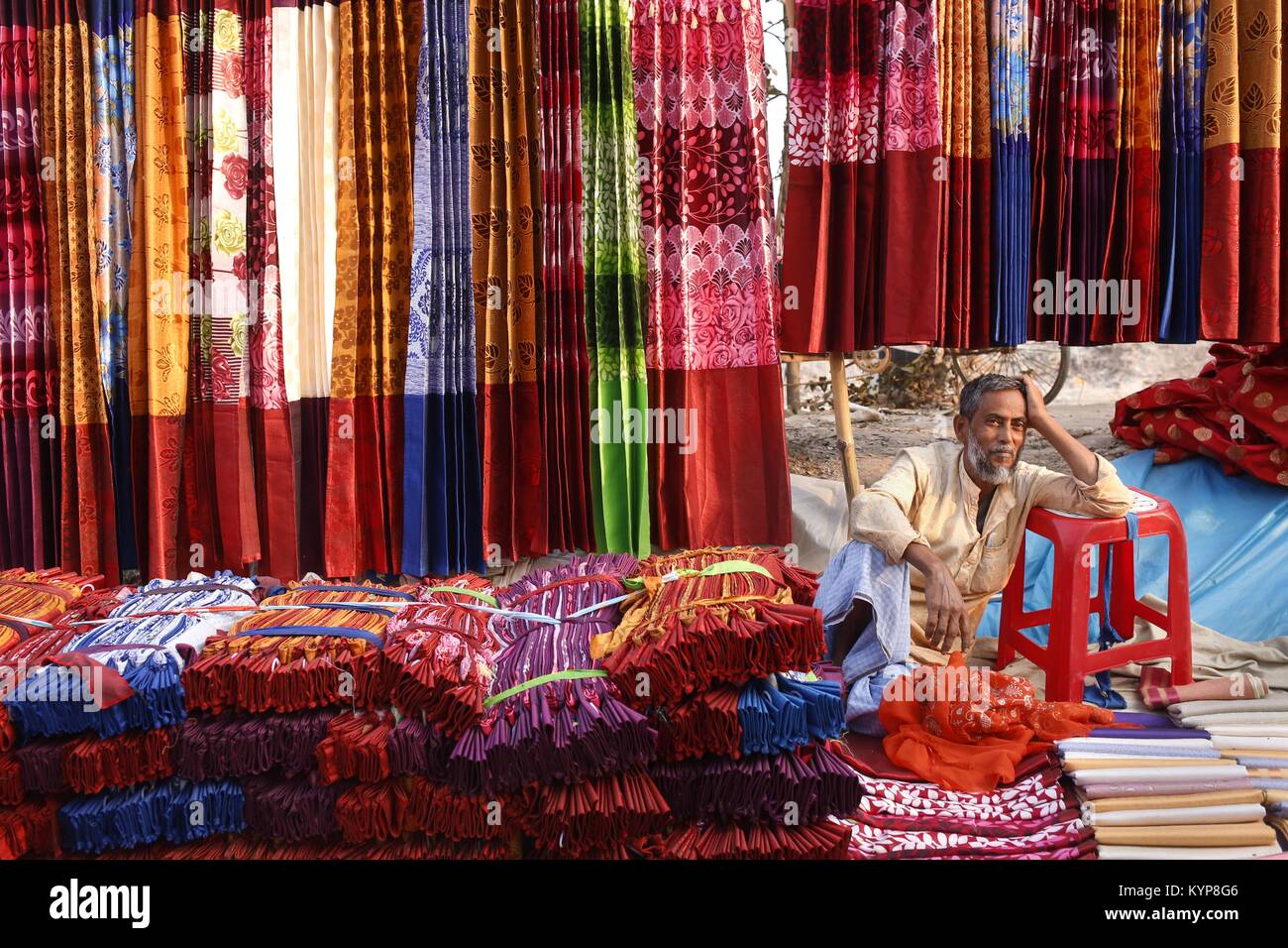 Dhaka, Bangladesh. 16th Jan, 2018. A street cloth vendor poses for a ...