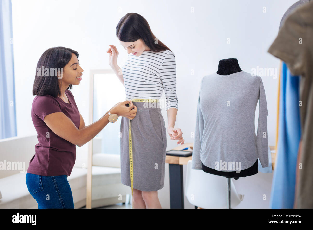 Satisfied woman waiting for her tailor to finish measurement Stock ...