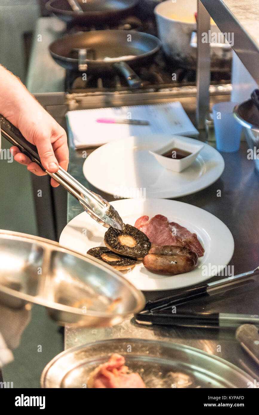 Food preparation - a chef preparing a breakfast in a restaurant kitchen ...