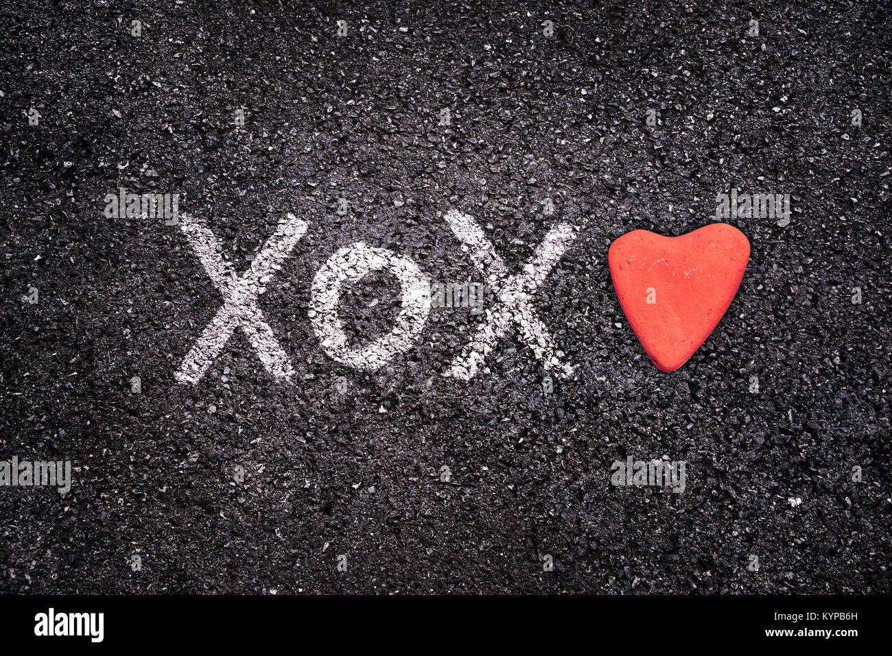 Happy Valentines day card, xoxo on the ground and stone in the shape of ...