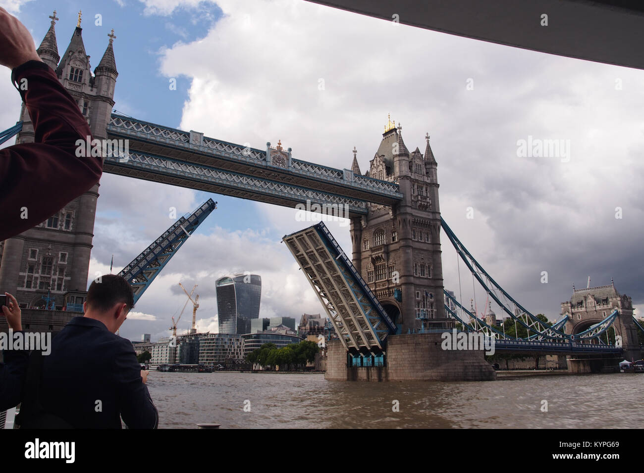 A view of Tower Bridge raised with people taking photographs taken from ...