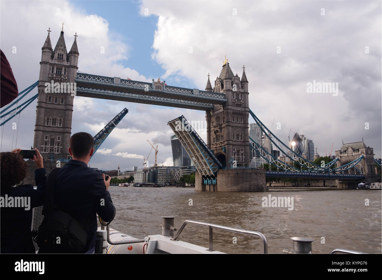 A view of Tower Bridge raised with people taking photographs taken from ...