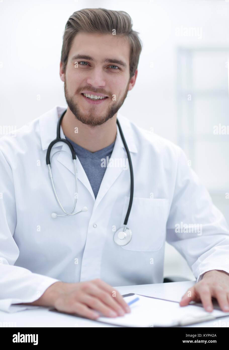 friendly doctor sitting behind a Desk Stock Photo - Alamy