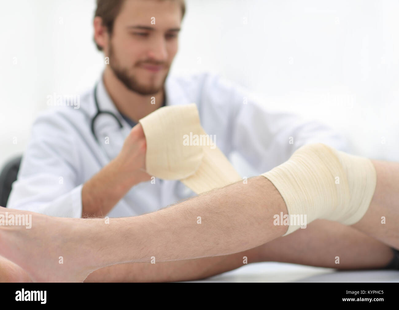doctor bandaging a wound on the leg of the patient Stock Photo - Alamy