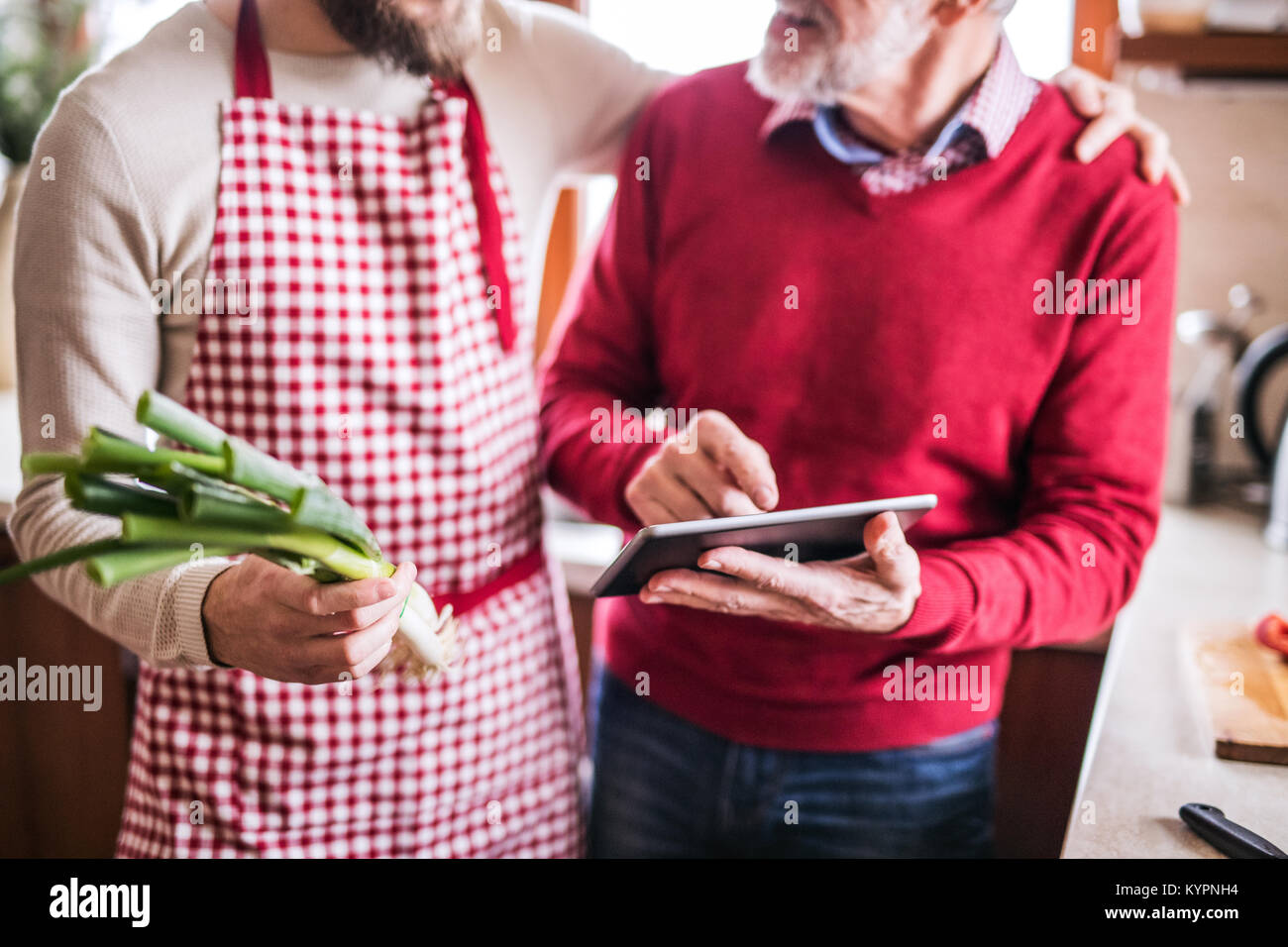 Hipster Son With His Senior Father With Tablet In The Kitchen Stock
