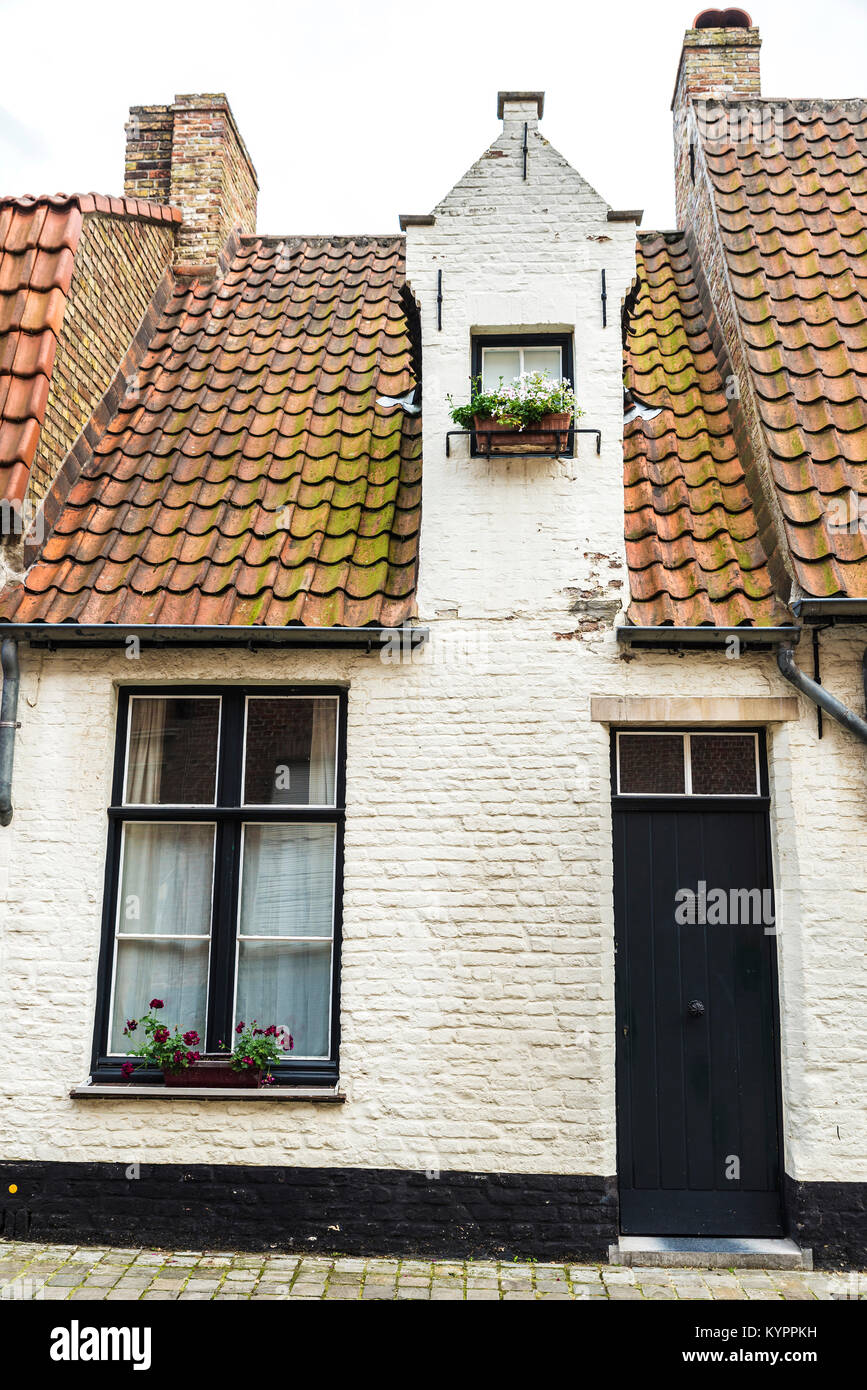Facade of an old white historic building in the medieval city of Bruges ...