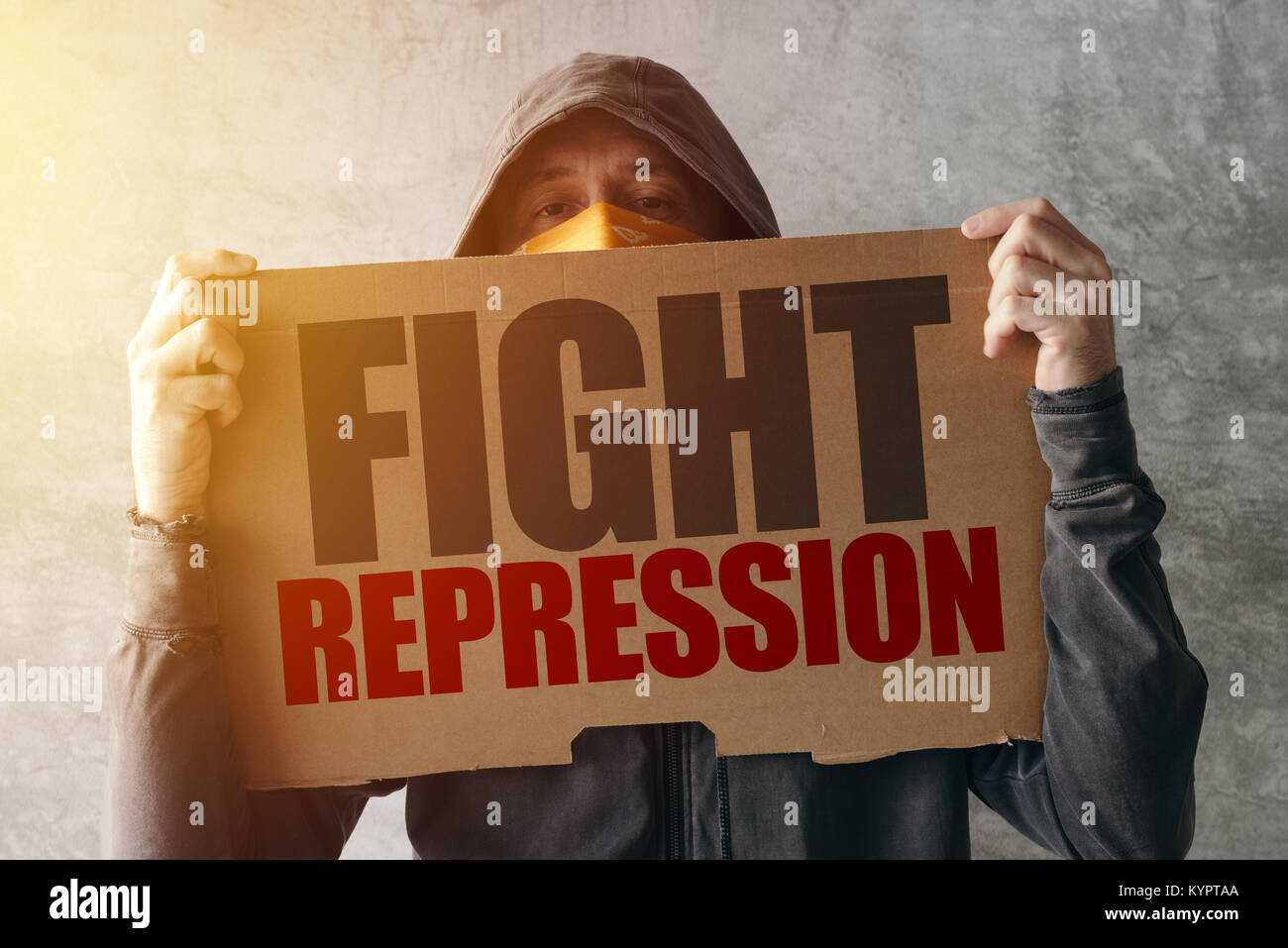 Hooded activist protestor holding Fight repression protest sign. Man ...