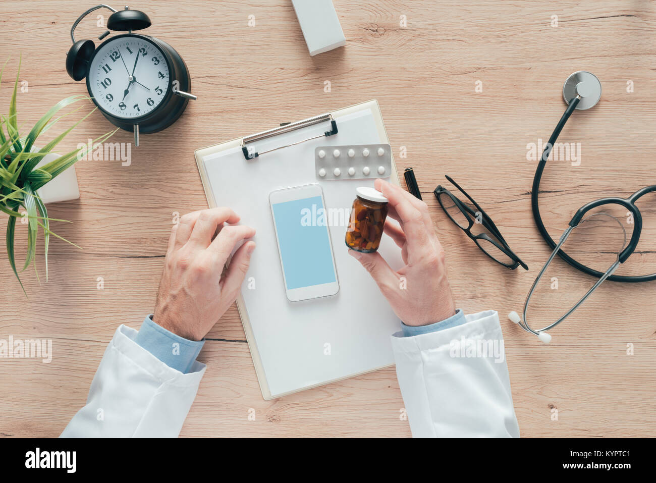 Overhead view of hospital office desk with male doctor holding ...