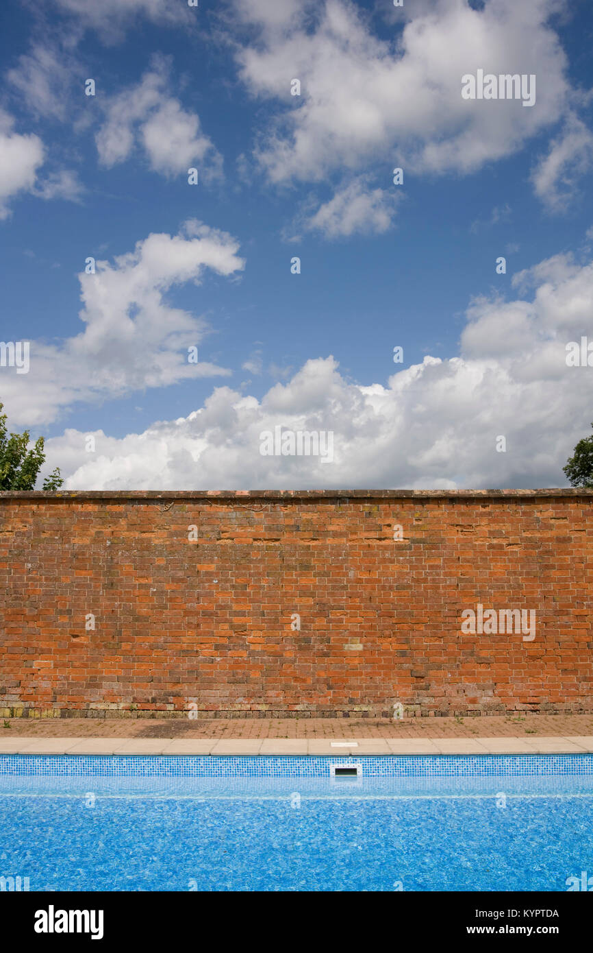 Old red brick wall contrasting with blue sky and swimming pool Stock ...