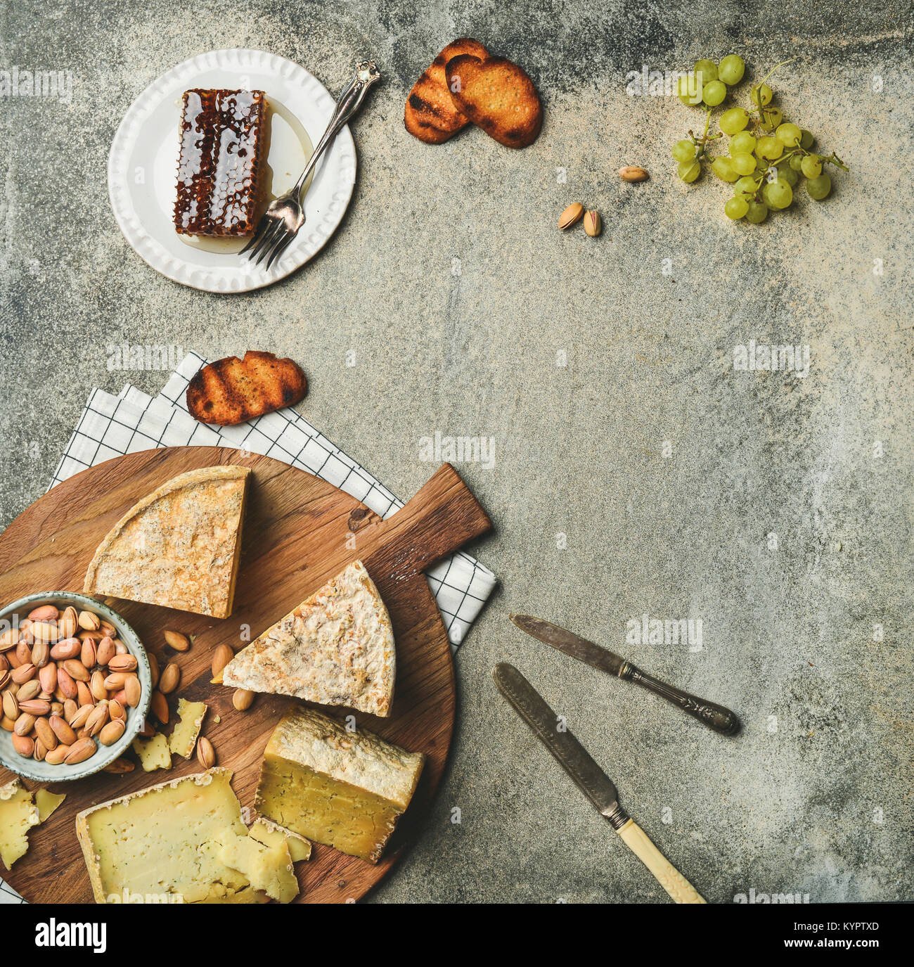 Flat-lay of cheese platter with cheese assortment, green grapes, bread ...