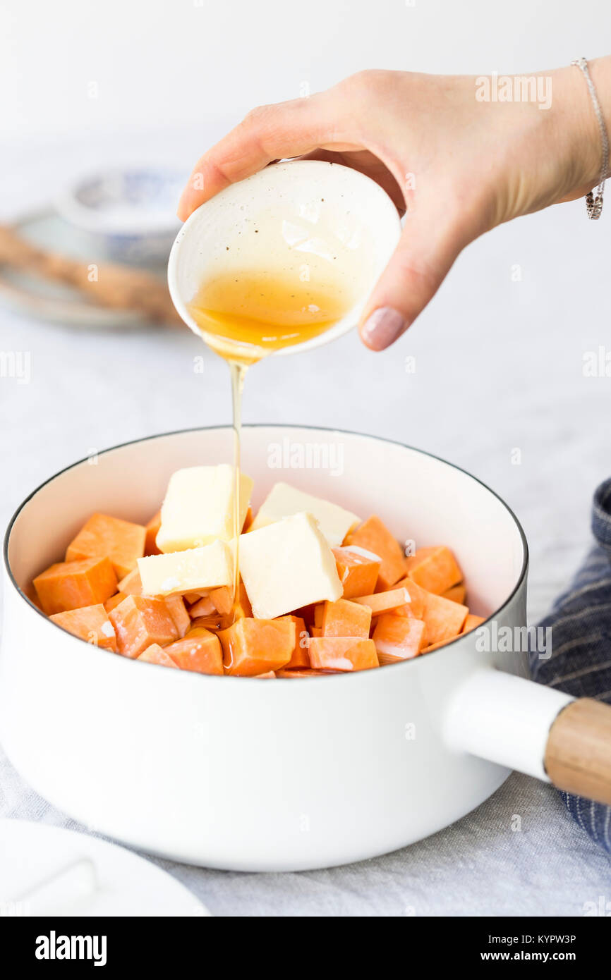 A woman's hand is photographed as she is drizzling maple syrup into ...
