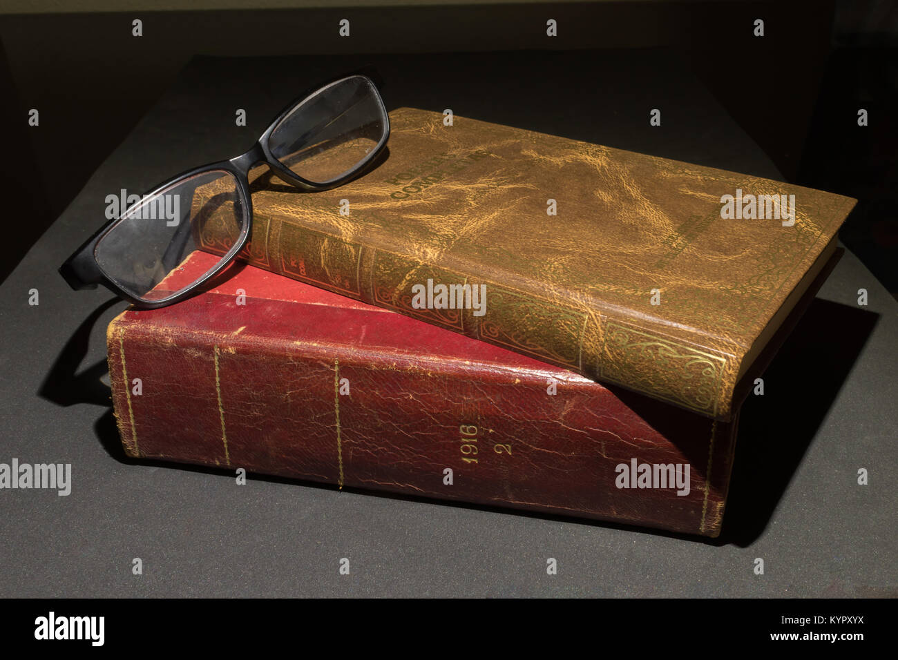 Vintage red and brown poetry books with a black glass on black ...