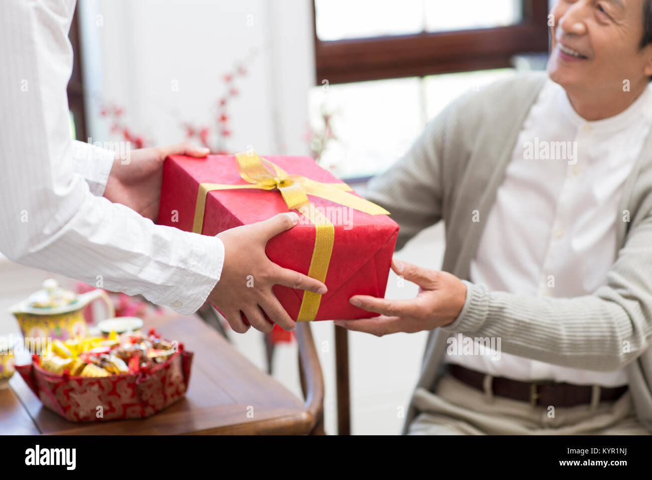 Son giving gift to his father during Chinese New Year Stock Photo - Alamy